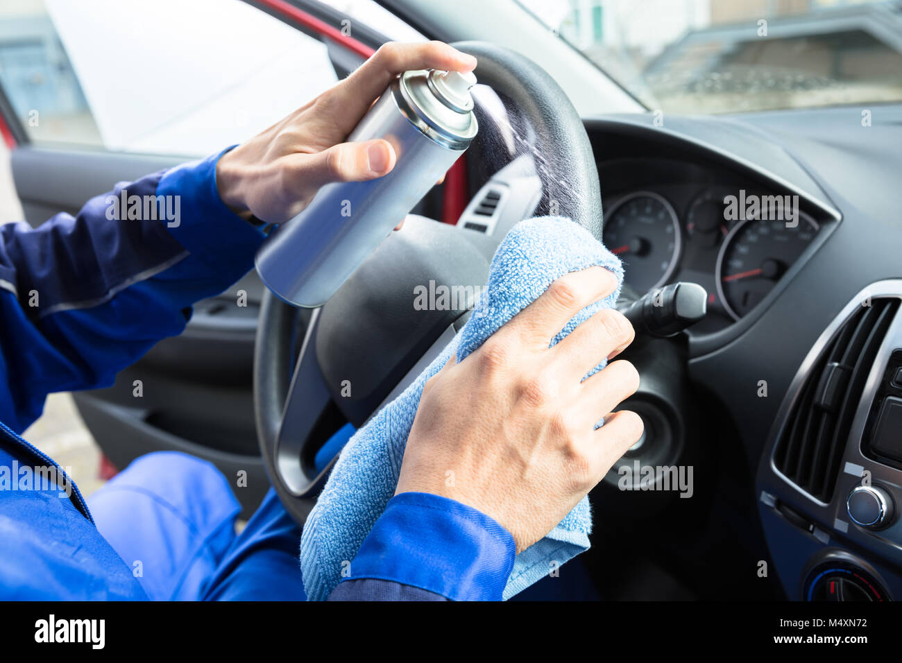 Close-up Of Worker's Hand Cleaning Car Steering Wheel Using Spray Can ...