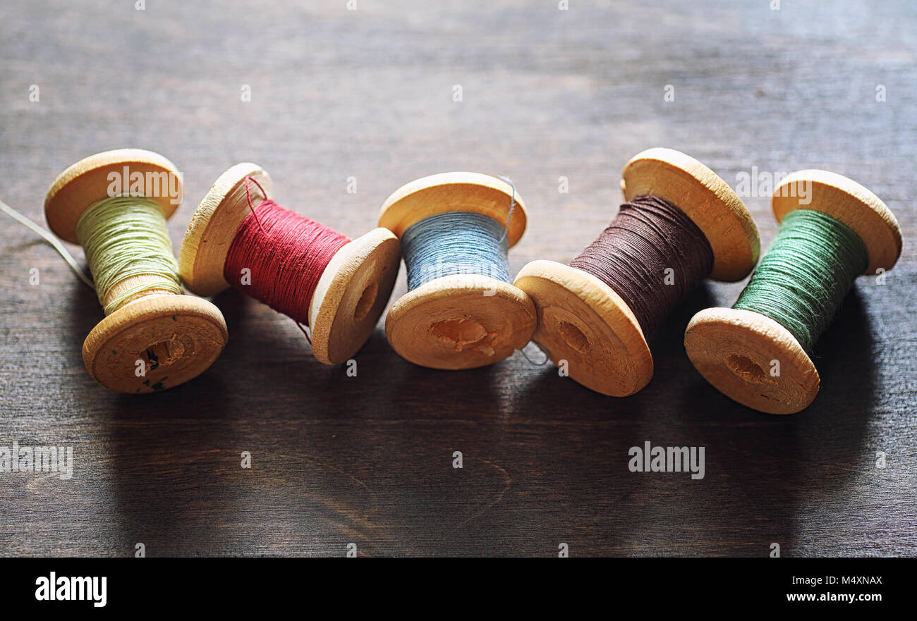 Sewing thread on a wooden background. Set of threads on bobbins Stock ...