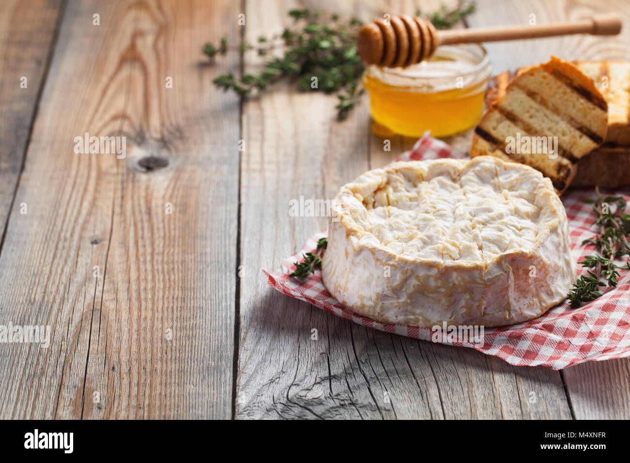 A real Camembert from France with thyme, honey and toasted bread on old ...