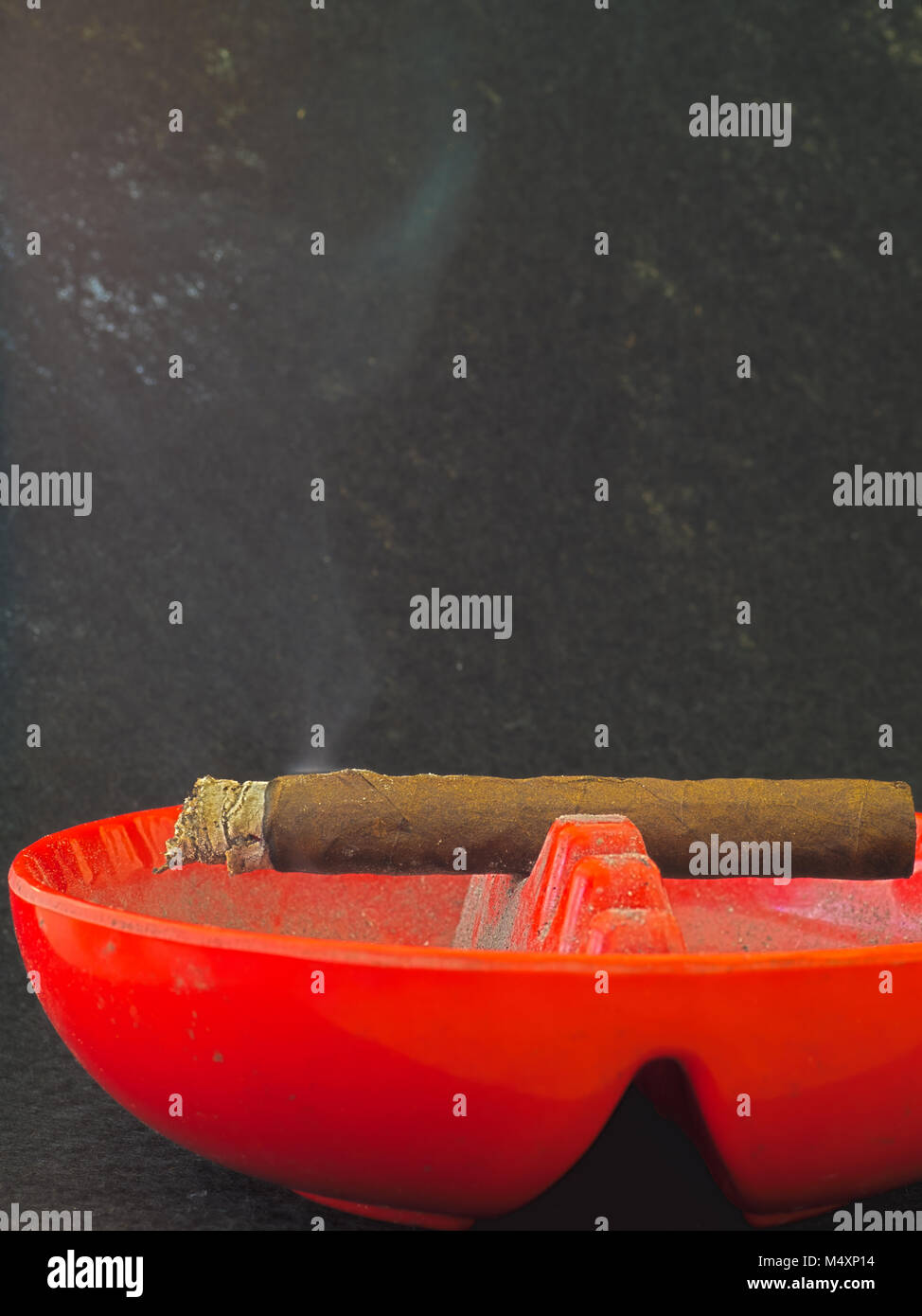 HDR photo of a cigar burning in a dirty ash tray Stock Photo - Alamy