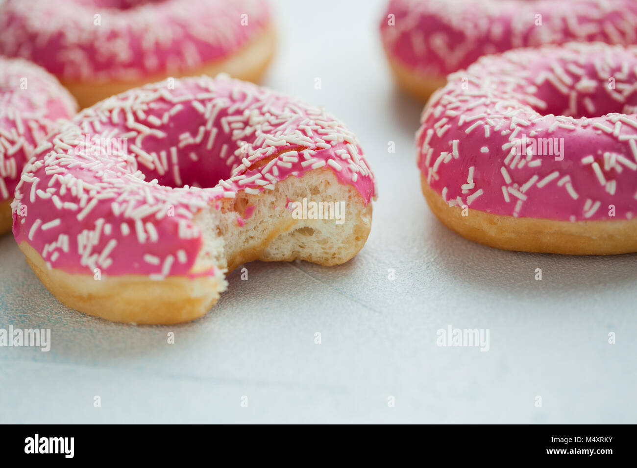 Bitten donut. Sweet icing sugar food. Dessert colorful snack. Glazed ...