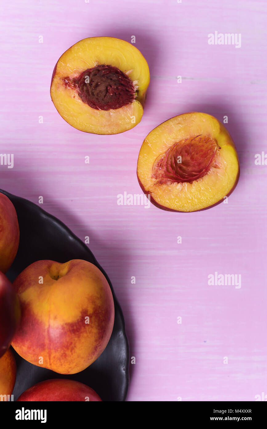 composition of ripe peaches on a pink background Stock Photo - Alamy