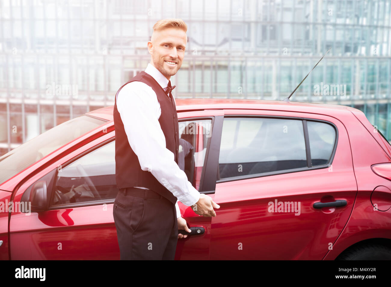 Portrait Of A Handsome Young Male Valet Opening Red Car Door Stock ...