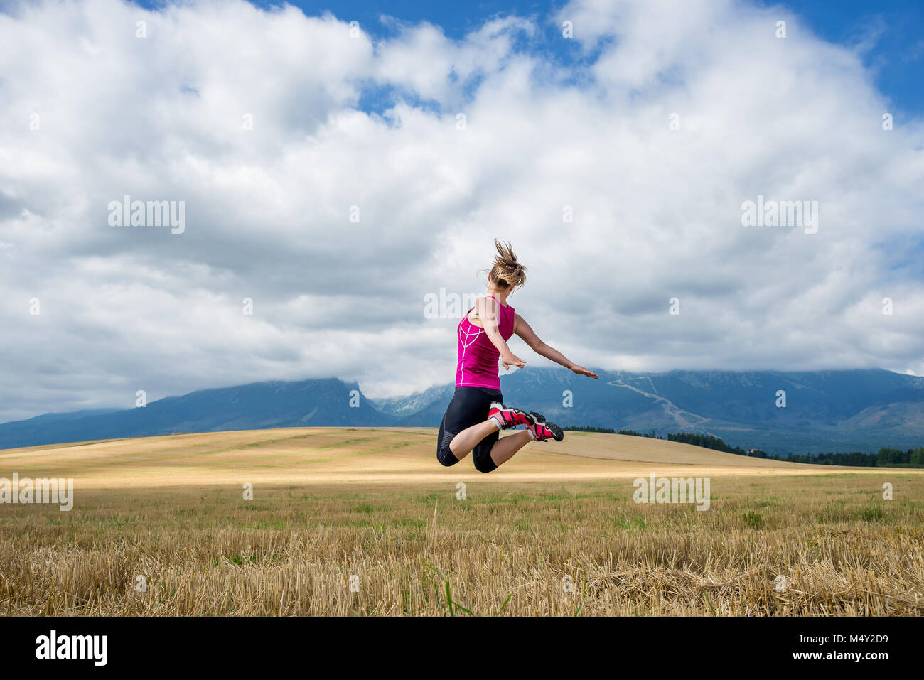 Young woman jumping in the mountains Stock Photo - Alamy