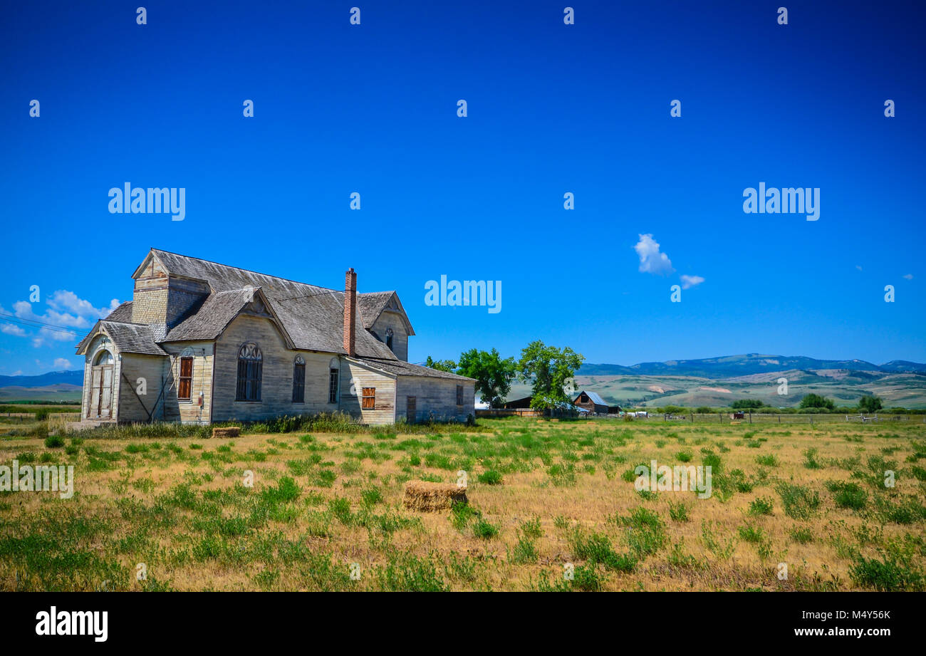 A deserted gray wooden house on an abandoned ranch on a lonely road in ...