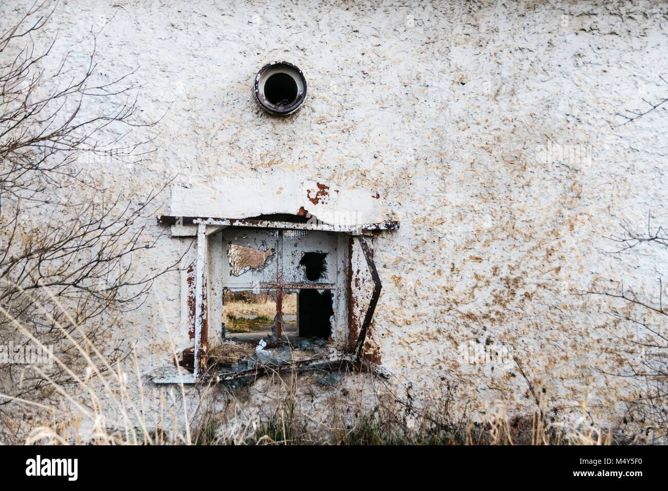 A broken window on an old house. Dirty gray, damaged wall Stock Photo ...