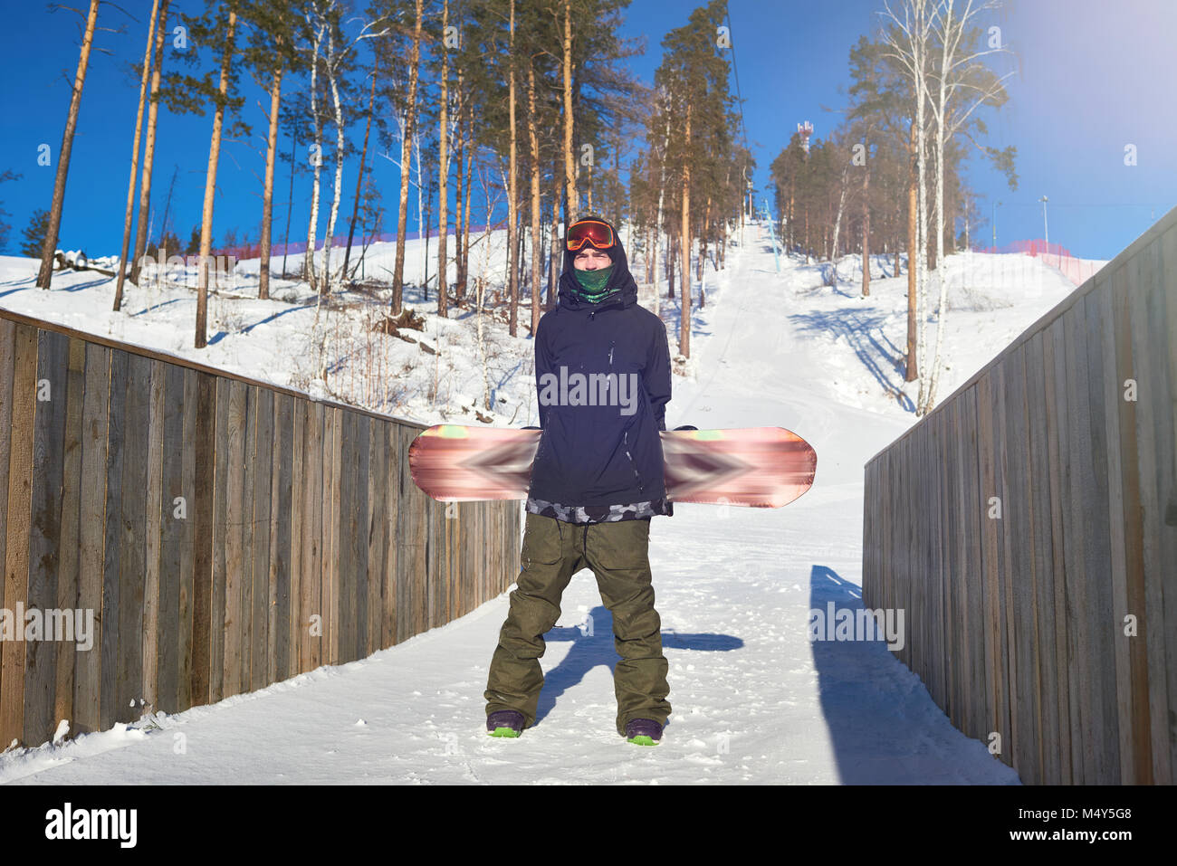 Full length portrait of modern young man posing with snowboard and ...