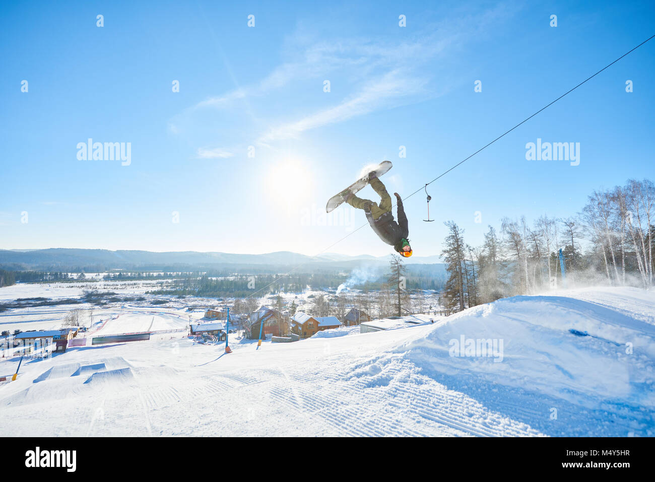 Full length action shot of young man performing snowboarding stunt ...