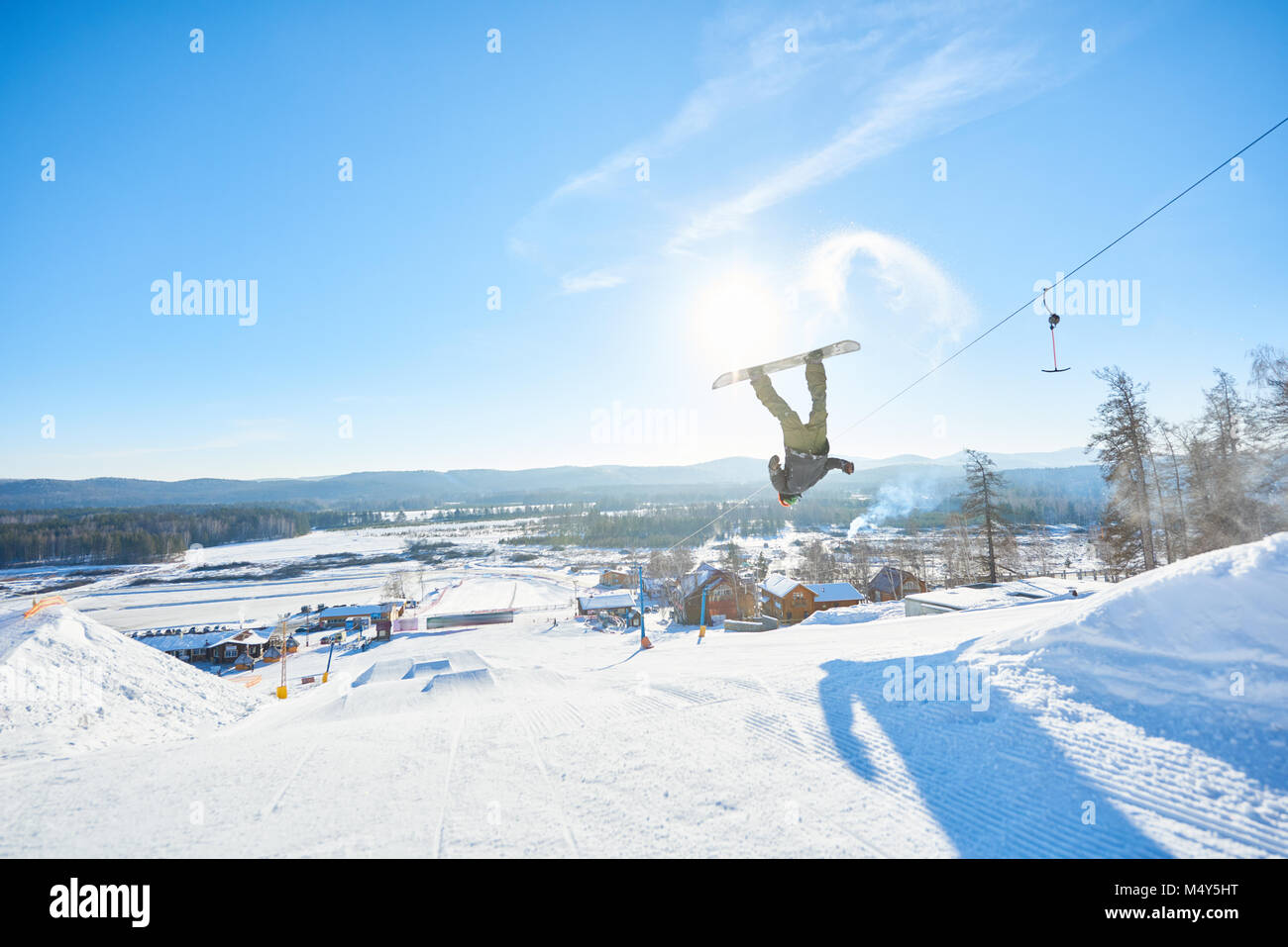 Full length action shot of young man performing snowboarding stunt ...