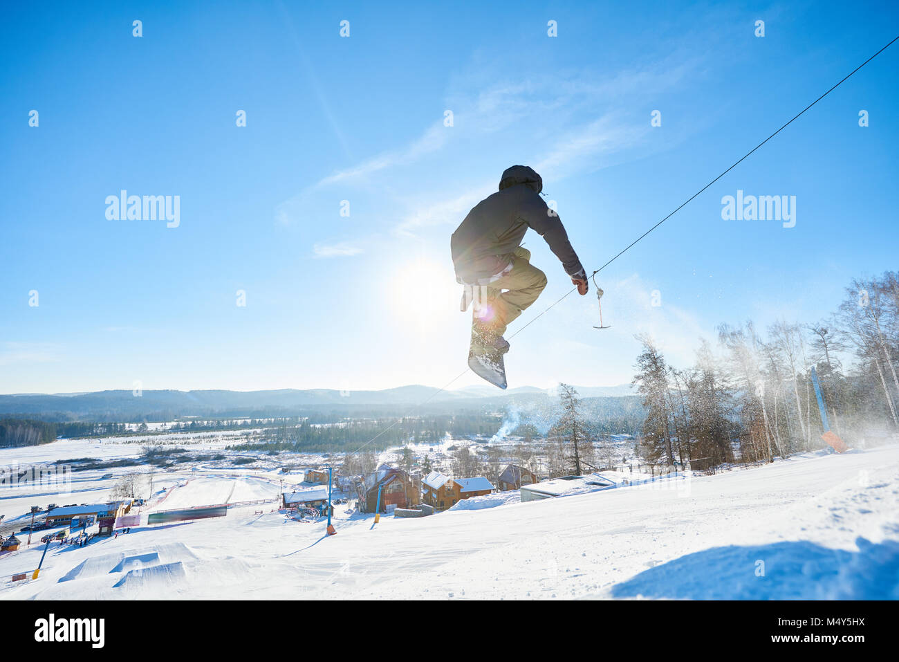 Full length action shot of young man performing snowboarding stunt ...