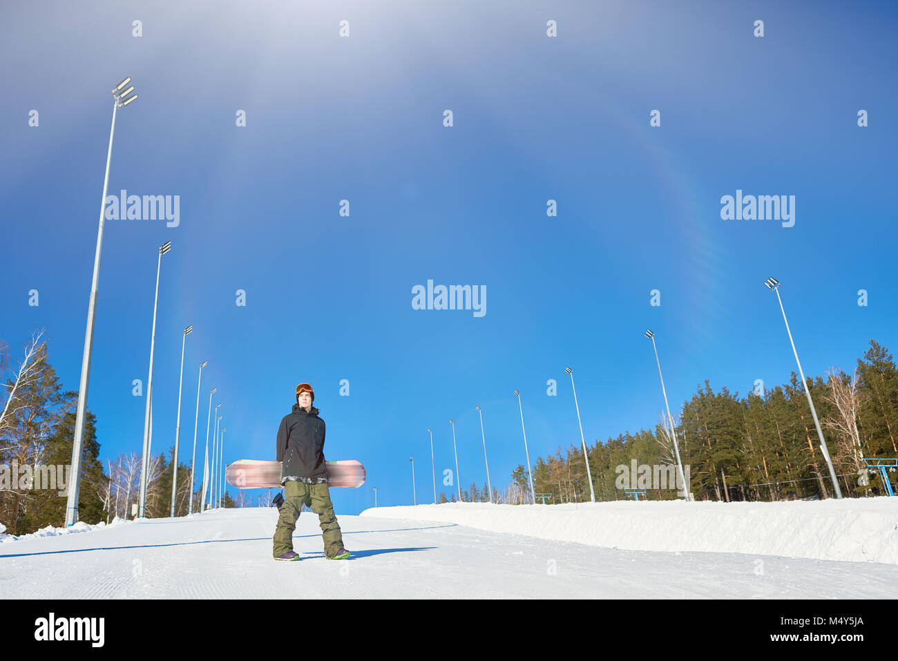 Full length wide angle portrait of modern young snowboarder posing on ...