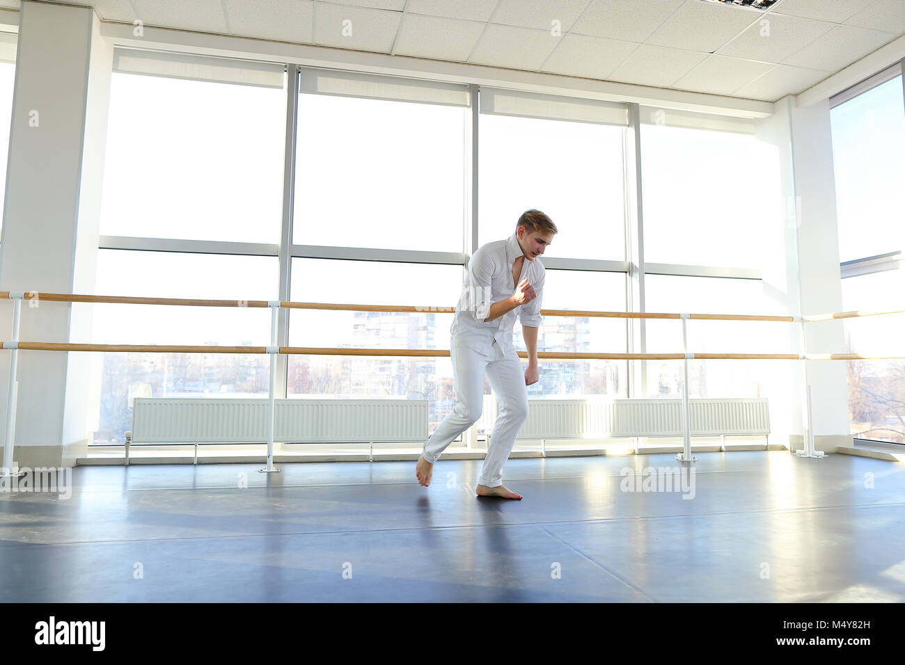 Guy dancing in tectonic style in white suit Stock Photo - Alamy