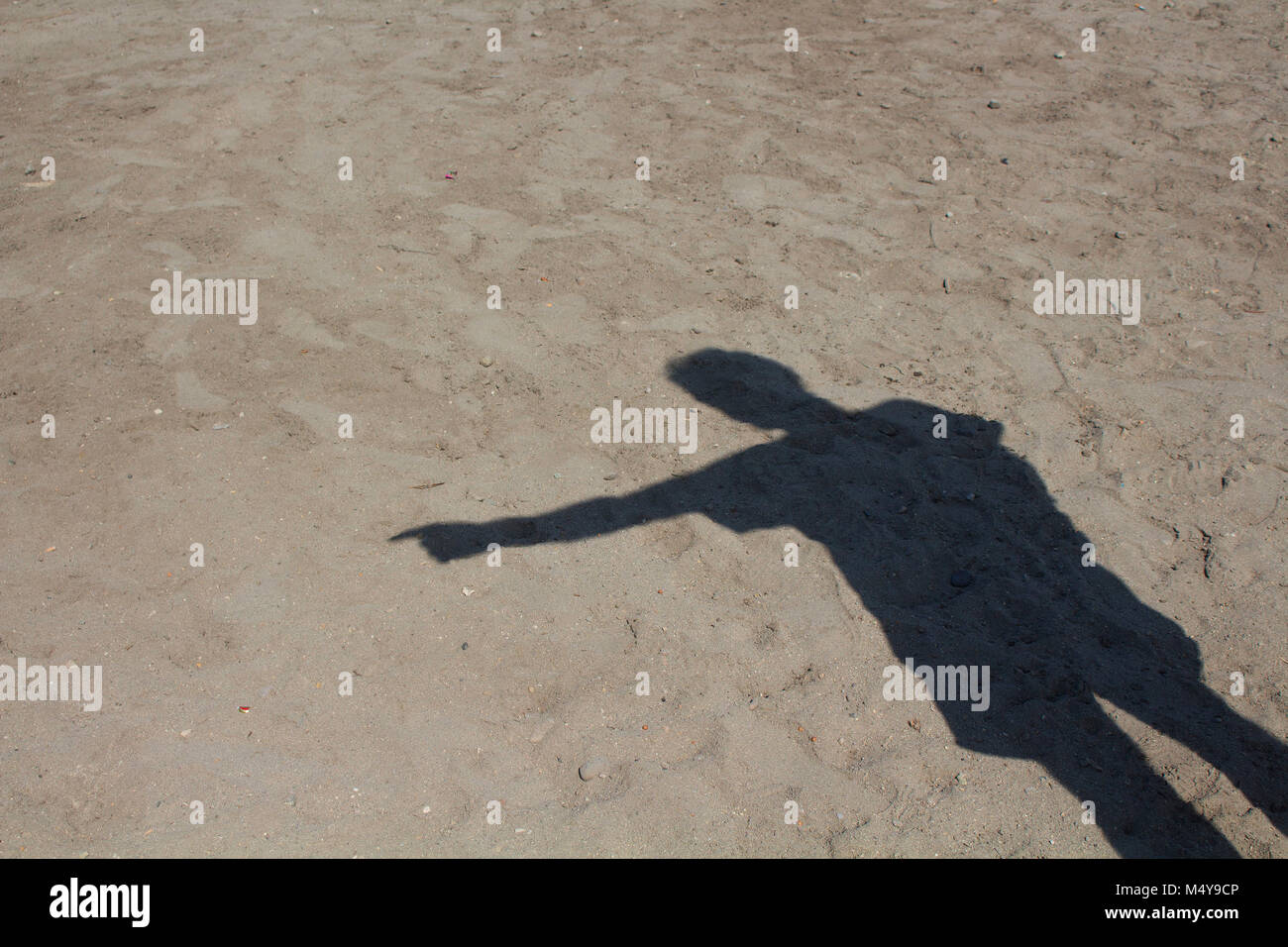 Shadow of man pointing on sand background Stock Photo - Alamy