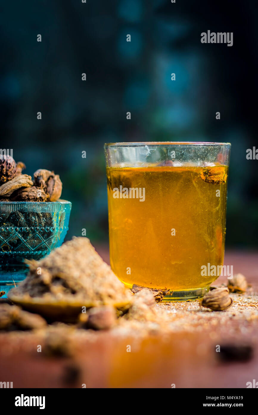Close up of water of Black cardamom with its powder and raw whole black ...