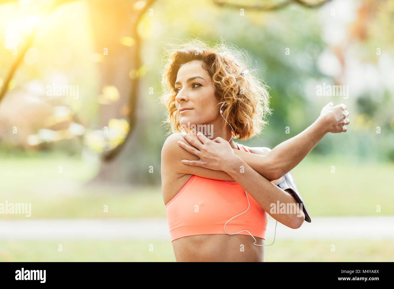 young fitness woman runner stretching arm before run Stock Photo - Alamy
