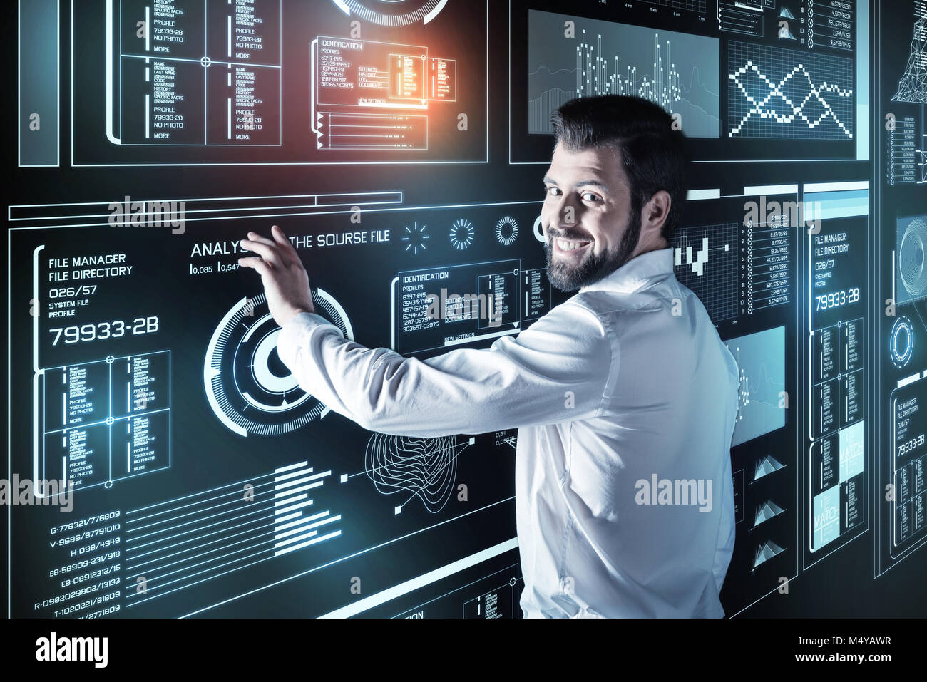 Smiling programmer touching the transparent screen while being at work Stock Photo - Alamy