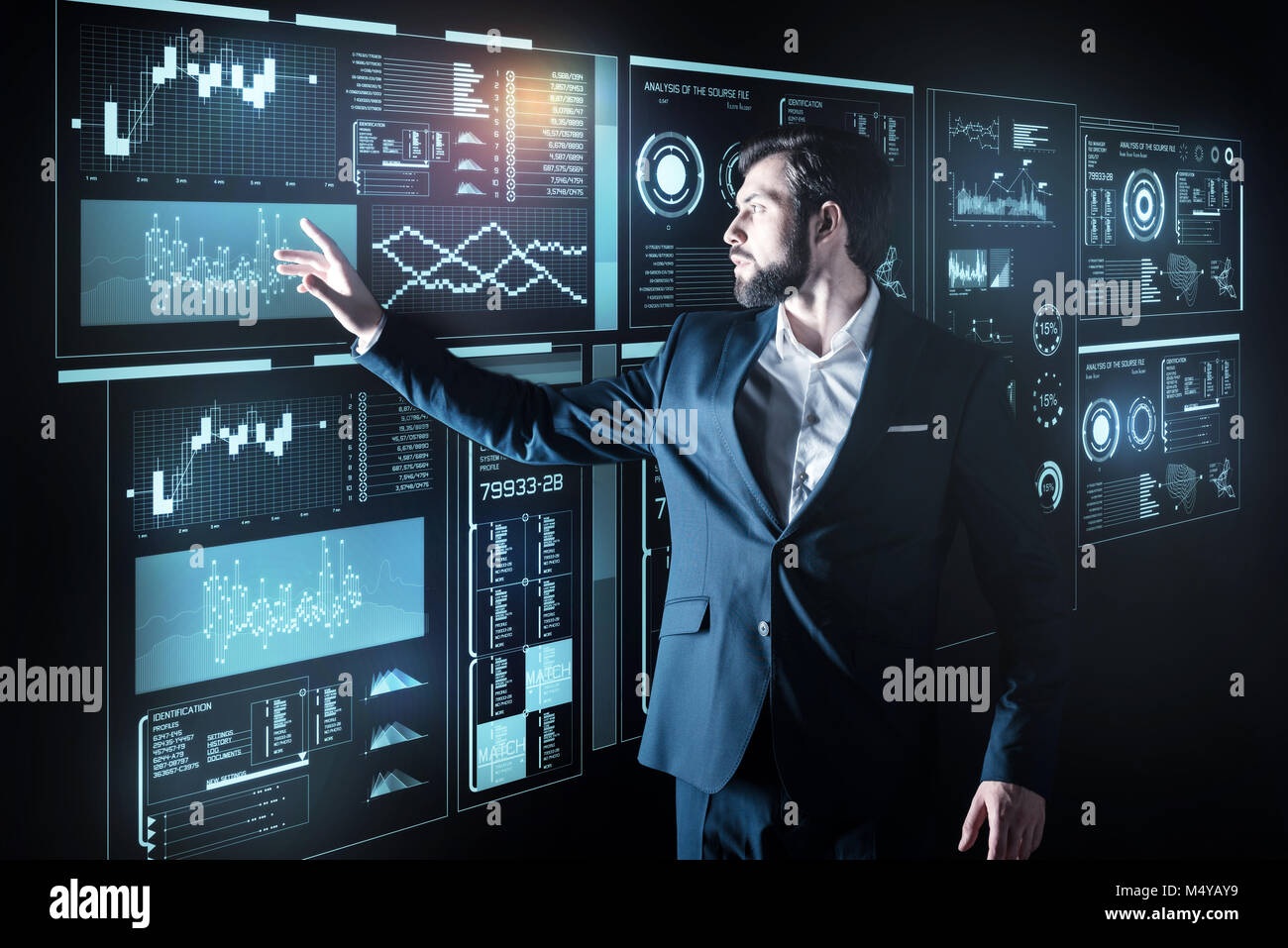 Smart man standing alone and touching the futuristic screen of his ...