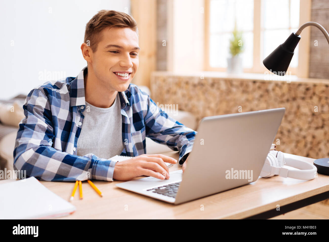 Inspired boy typing on his laptop Stock Photo - Alamy