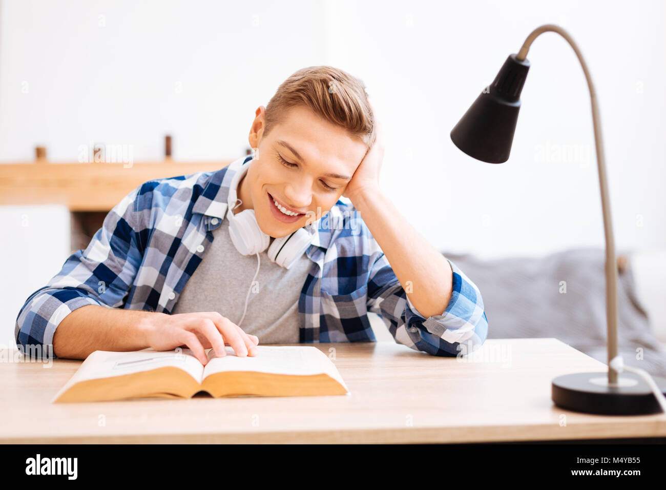 Cheerful boy reading a book at the table Stock Photo - Alamy