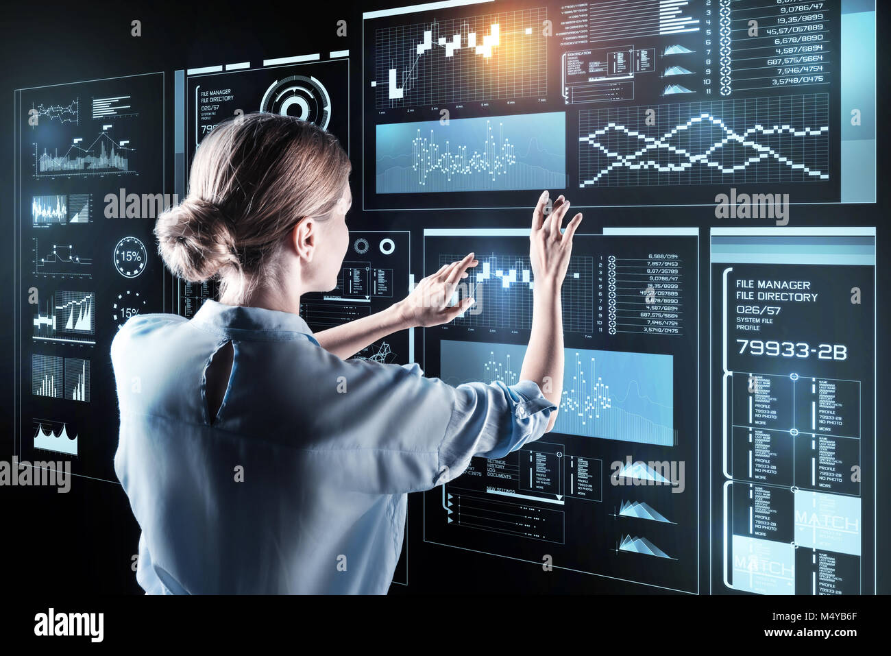 Calm woman slightly touching the screen while working alone Stock Photo ...