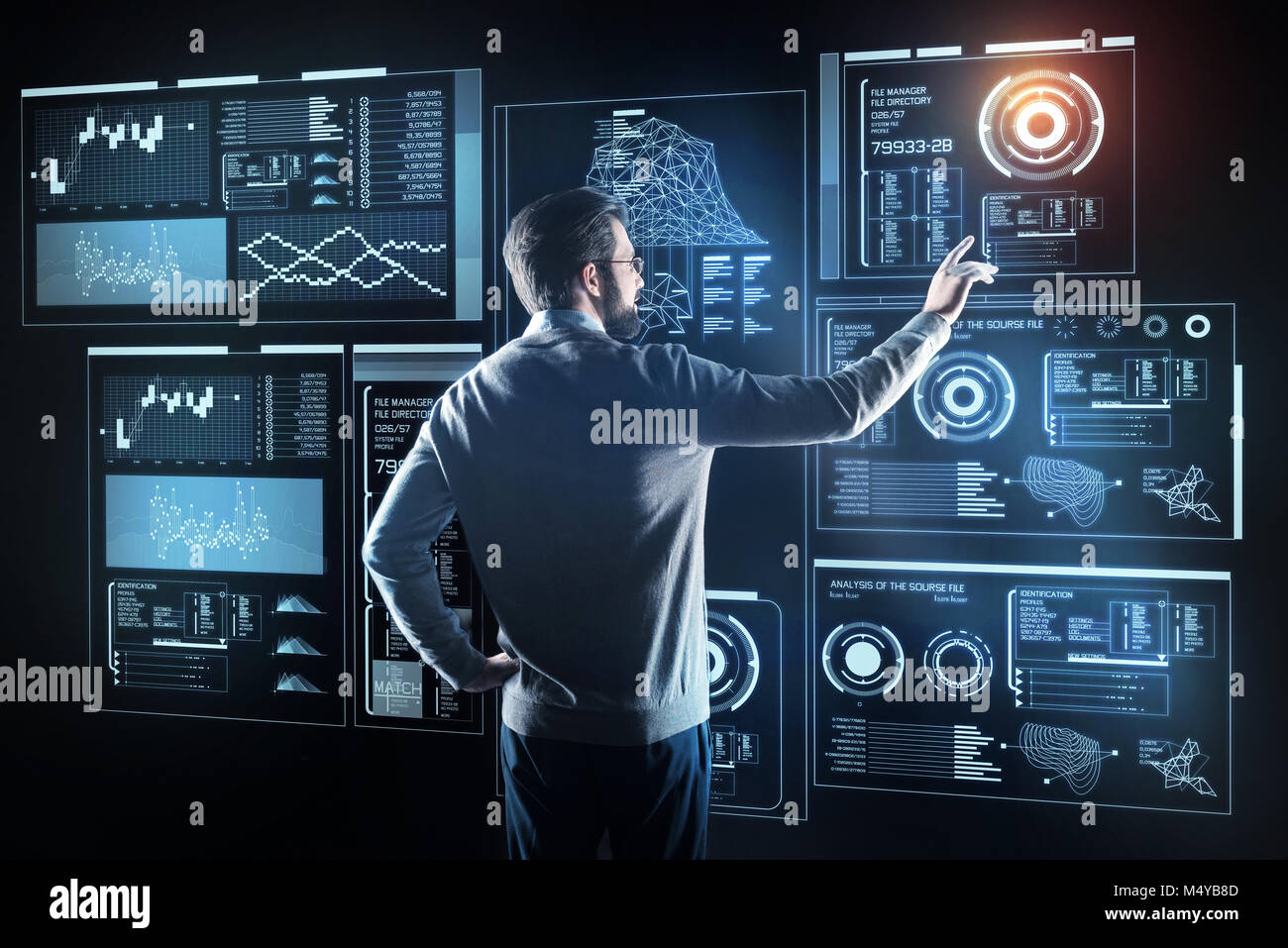 Calm bearded programmer pointing to the screen while working Stock ...