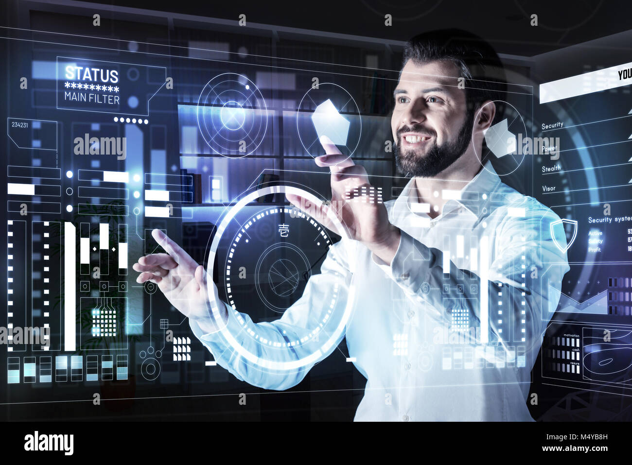 Positive man smiling while touching a futuristic screen Stock Photo - Alamy