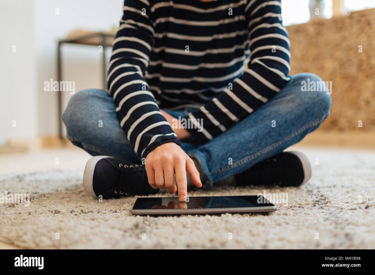 Adolescent touching his modern digital device Stock Photo - Alamy