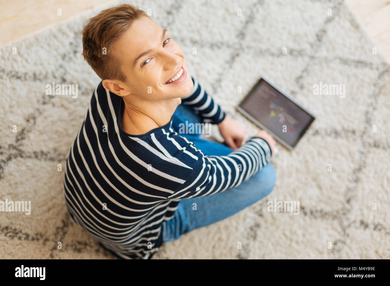 Smiling adolescent sitting on the floor Stock Photo - Alamy