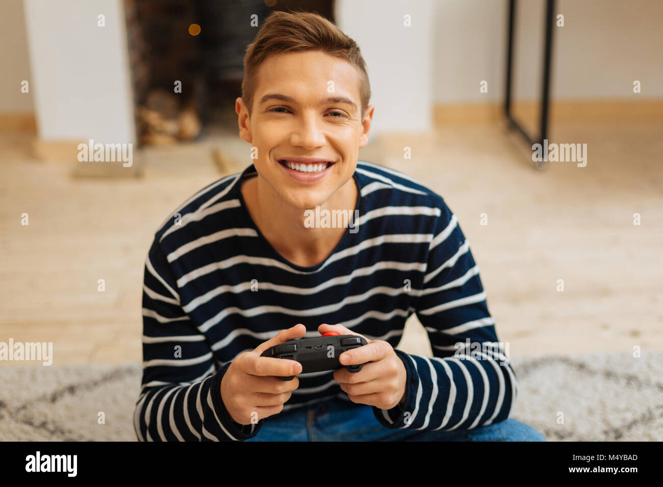 Inspired young man holding a remote control Stock Photo - Alamy