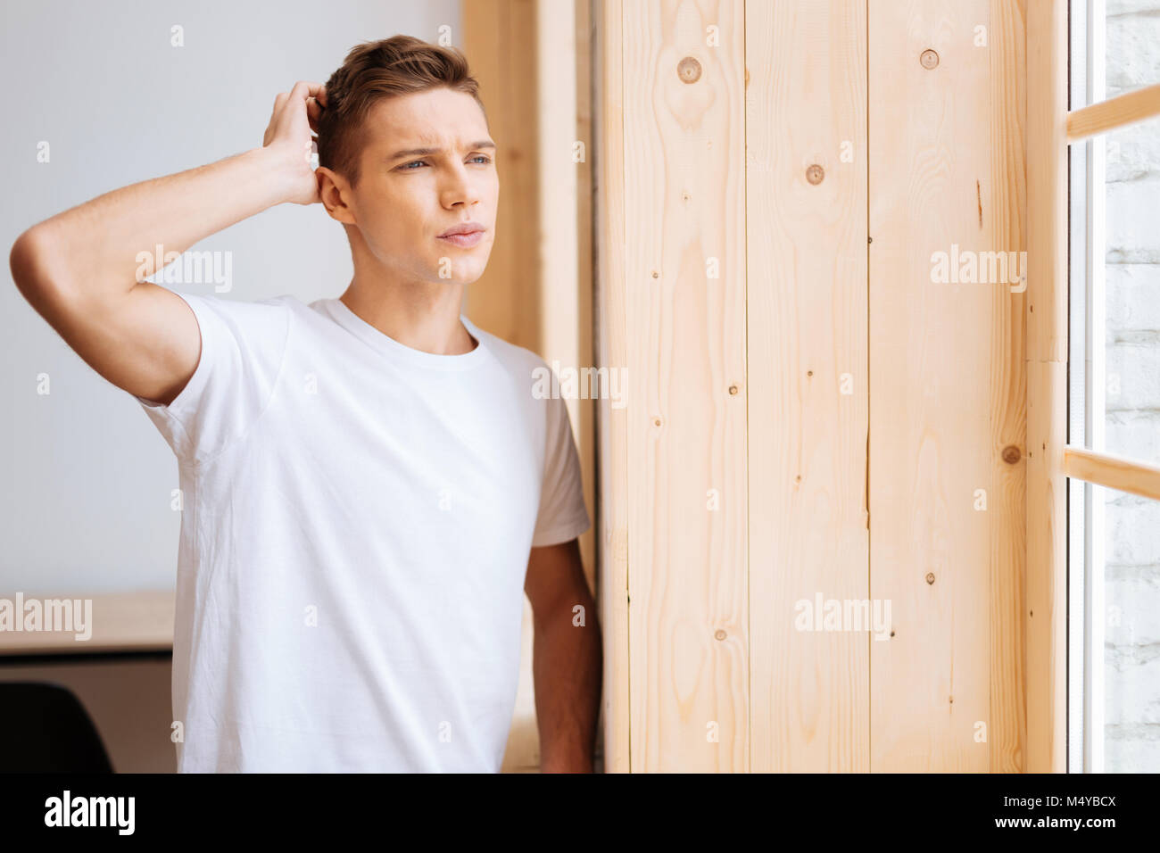 Sad young man looking out the window Stock Photo - Alamy