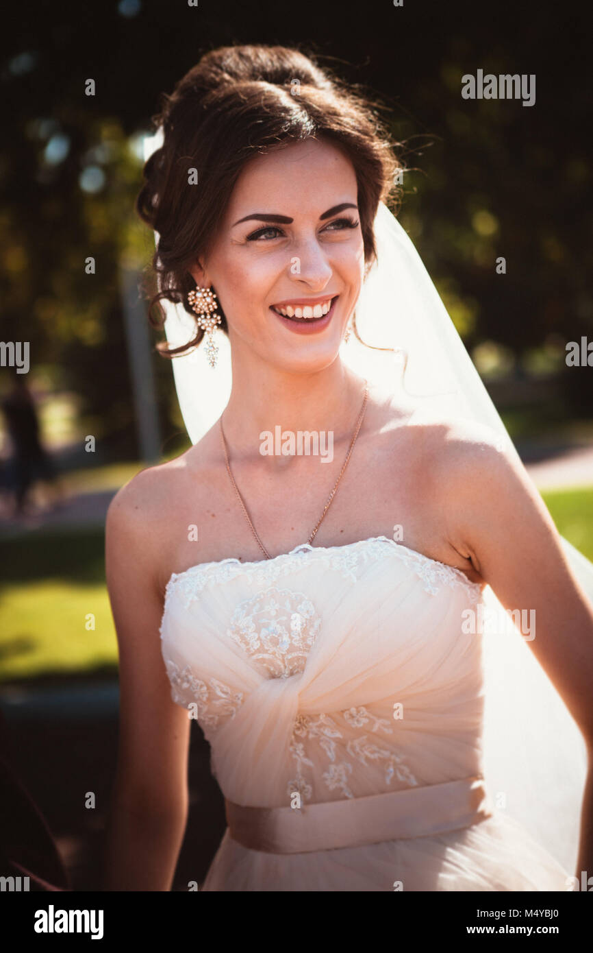 The beautiful brunette bride on a walk in park Stock Photo - Alamy