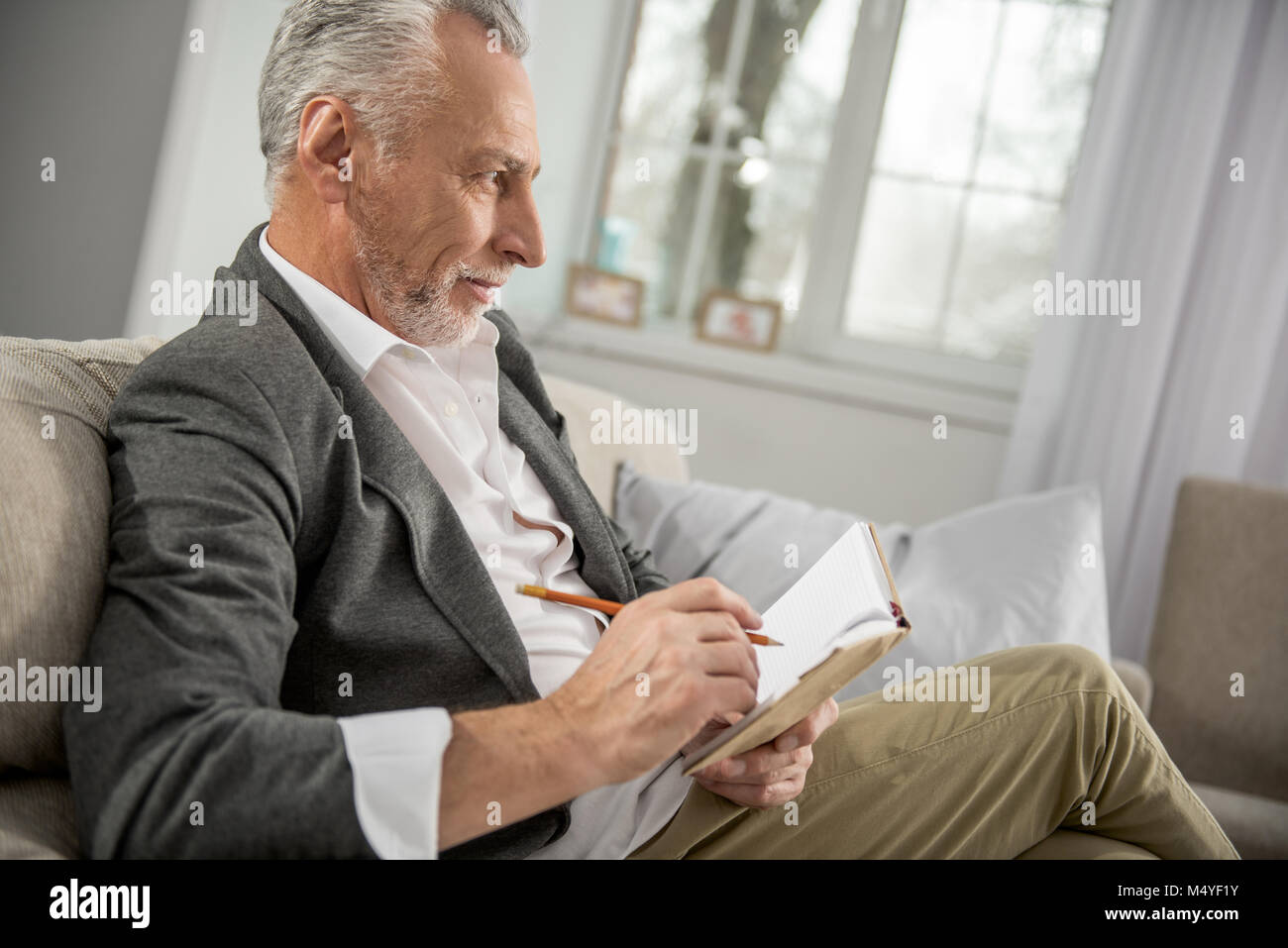 Profile photo of attentive man while writing Stock Photo - Alamy