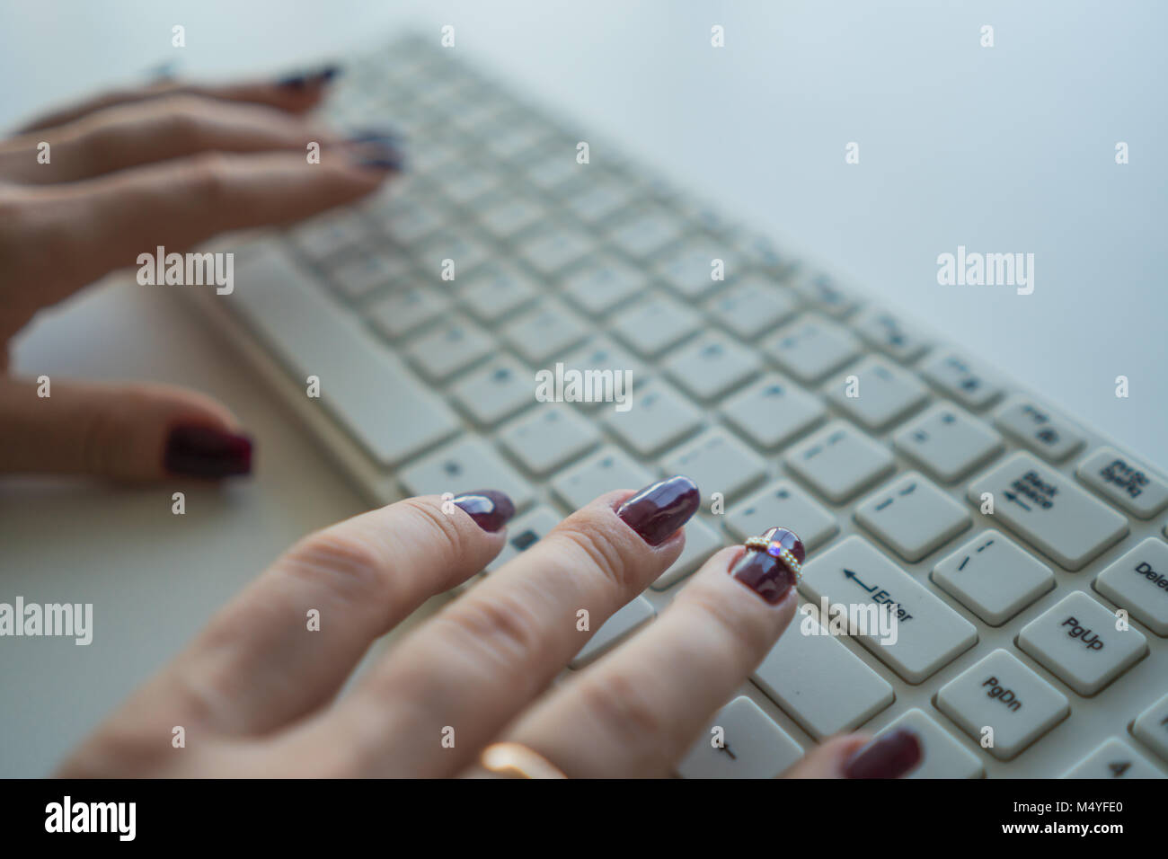 The girl is typing text on a computer keyboard. beautiful female hands ...