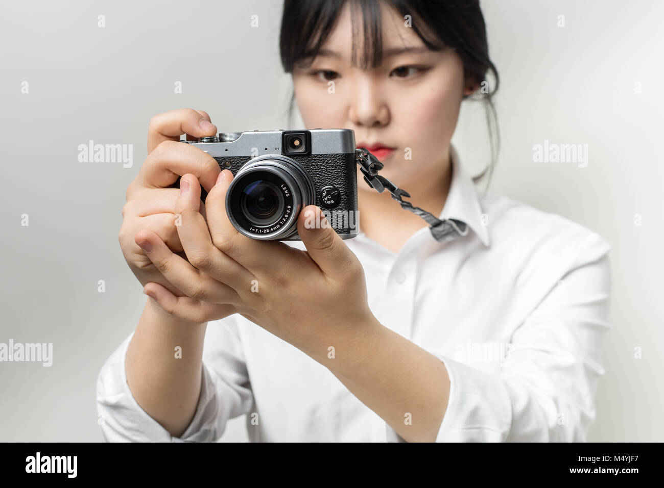 Female hand holding modern camera (mirrorless camera). camera in hand ...