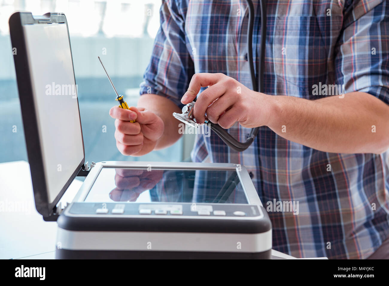 Repairman repairing broken color printer Stock Photo - Alamy