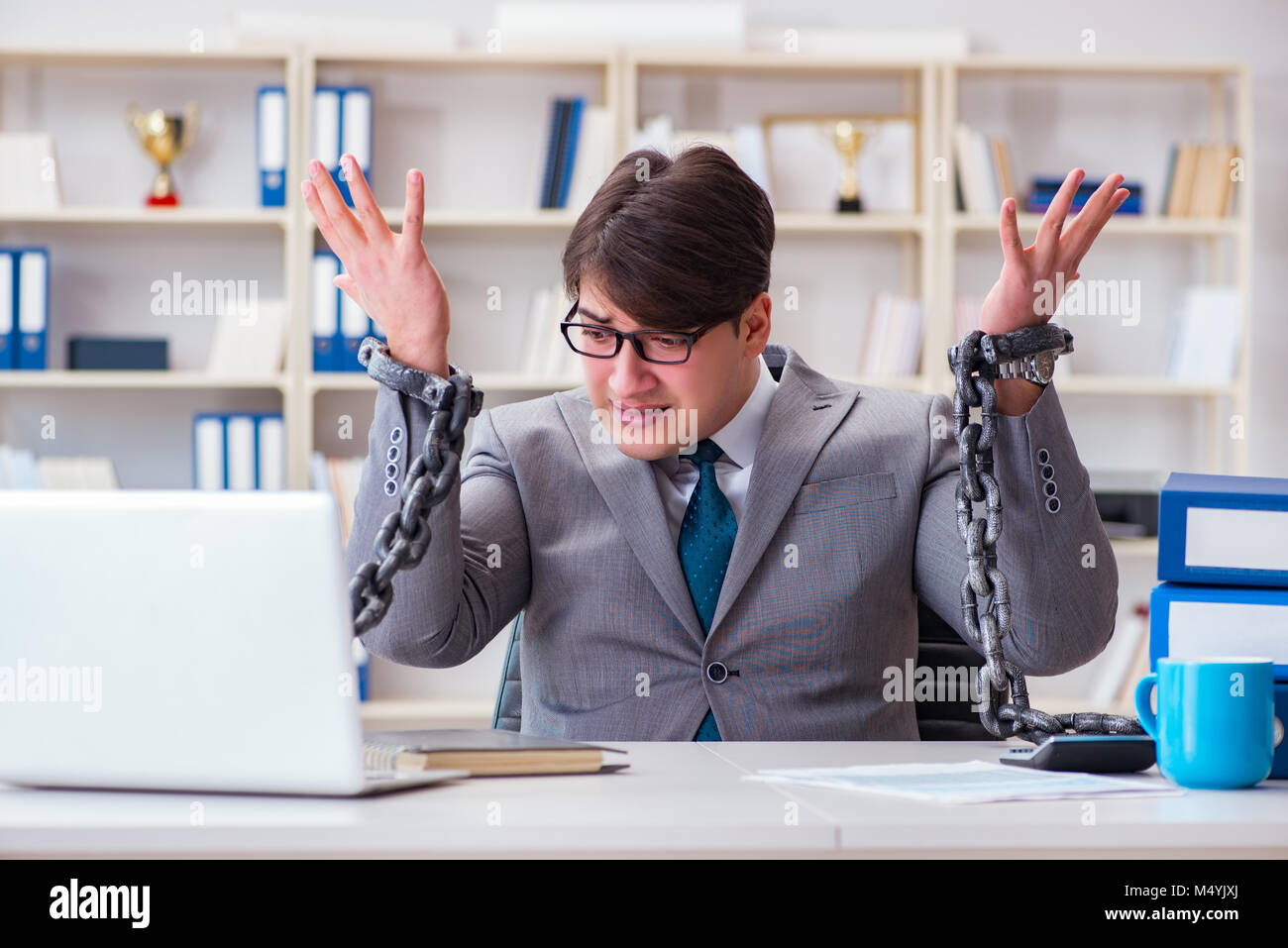 Businessman tied with chains to his work Stock Photo - Alamy