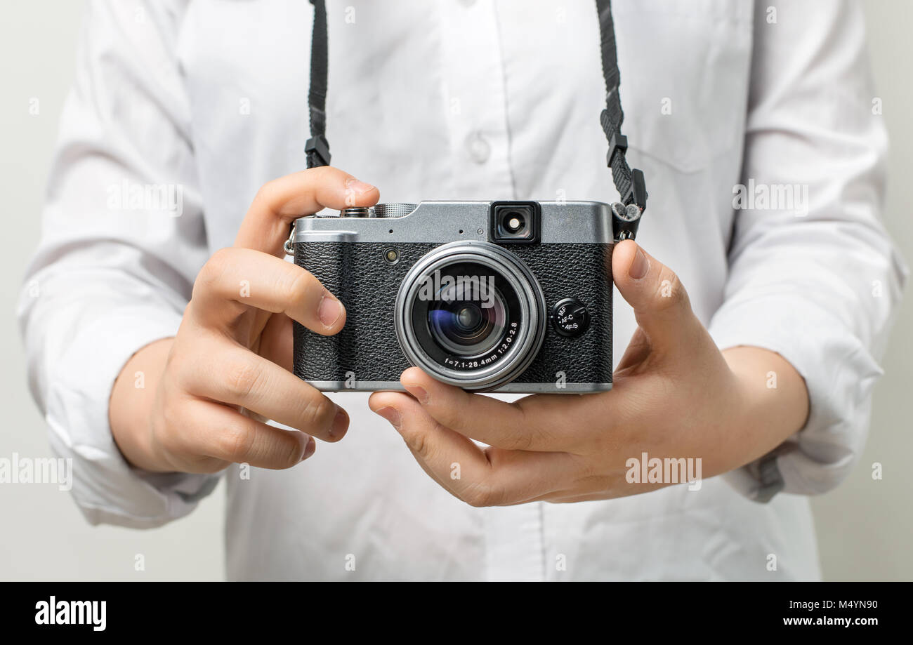 Female hand holding modern camera (mirrorless camera). camera in hand ...