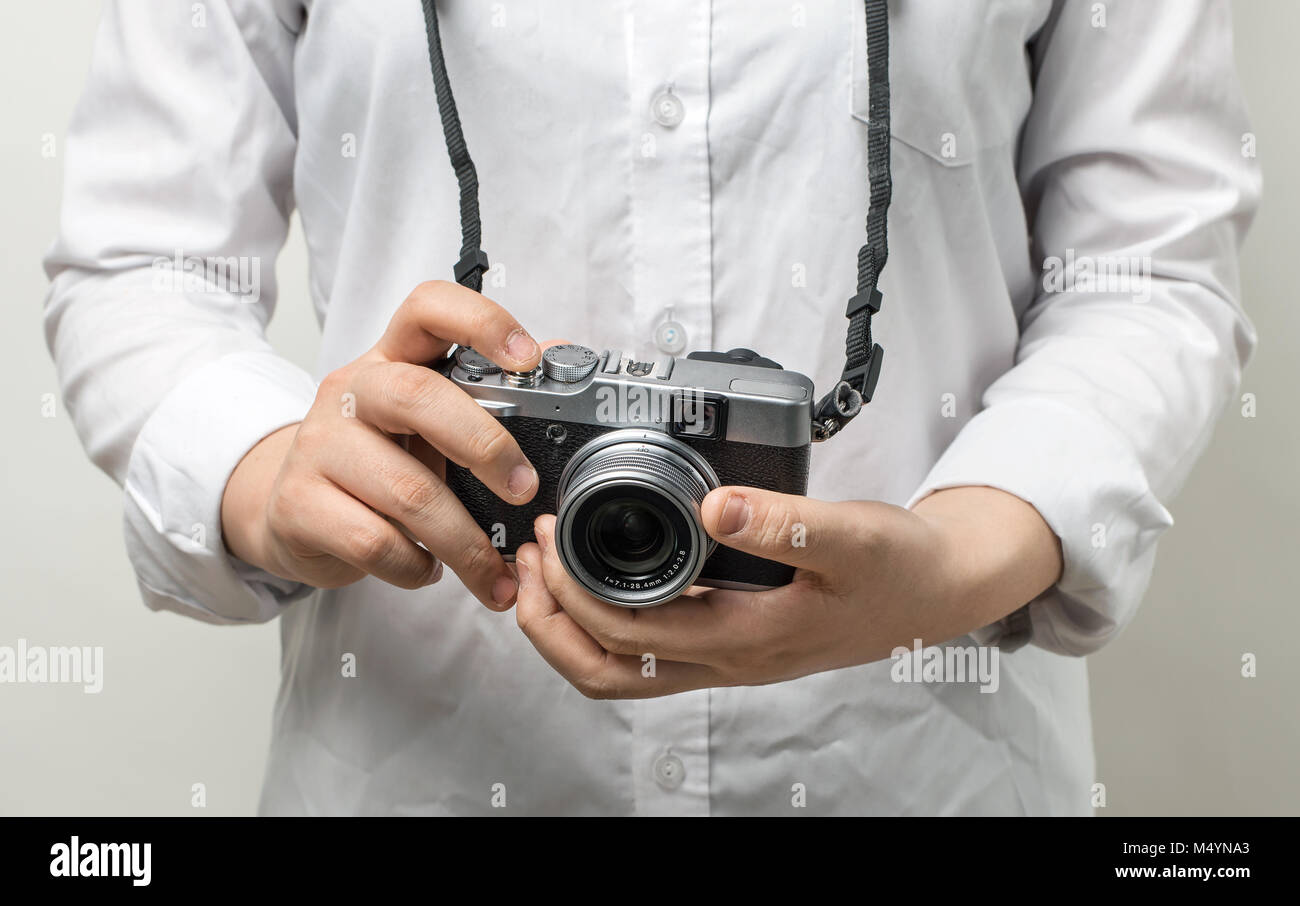 Female hand holding modern camera (mirrorless camera). camera in hand ...
