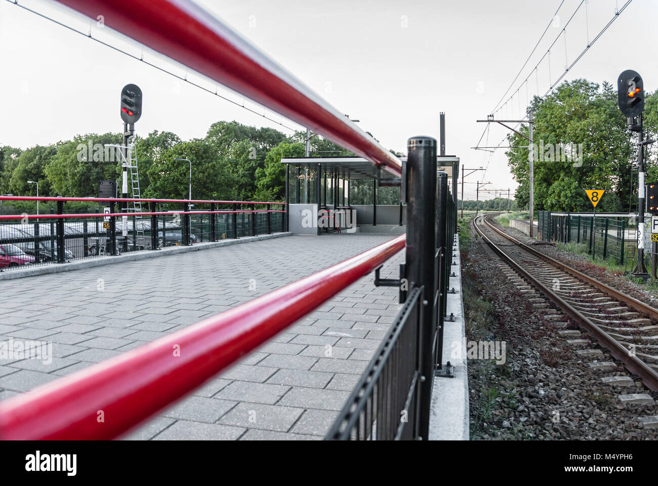 view of a train station with red railing to the left Stock Photo - Alamy