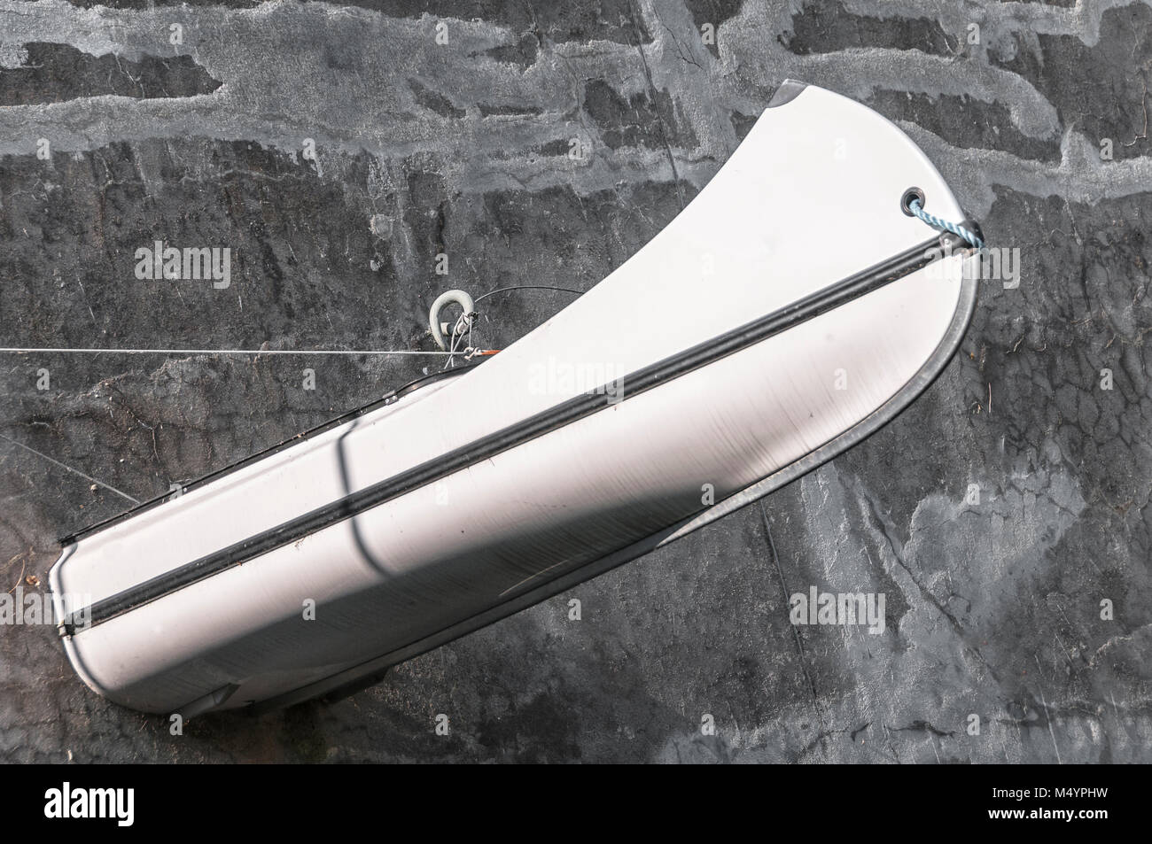 canoe sticking out of a concrete wall and tight with a steel cable ...