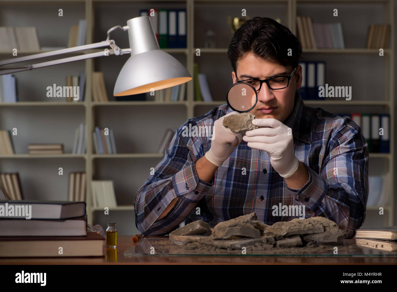 Archeologist working late night in office Stock Photo - Alamy