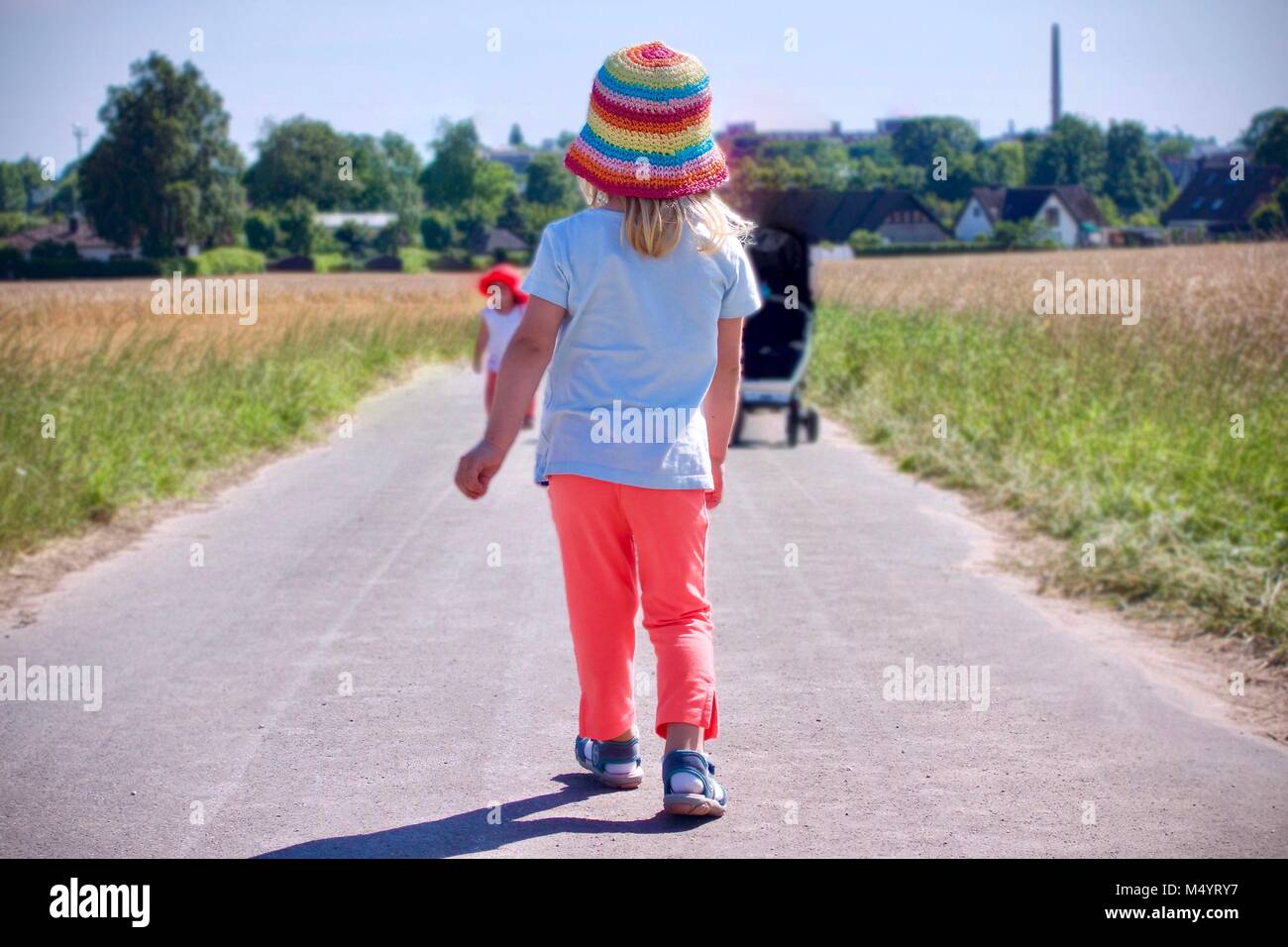 kid running down a country road with colorful cap and Stock Photo - Alamy