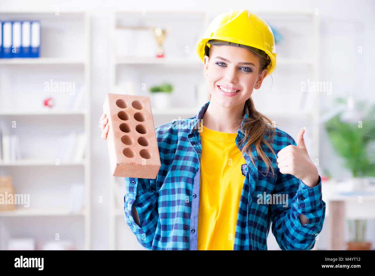Woman with brick in construction concept Stock Photo - Alamy