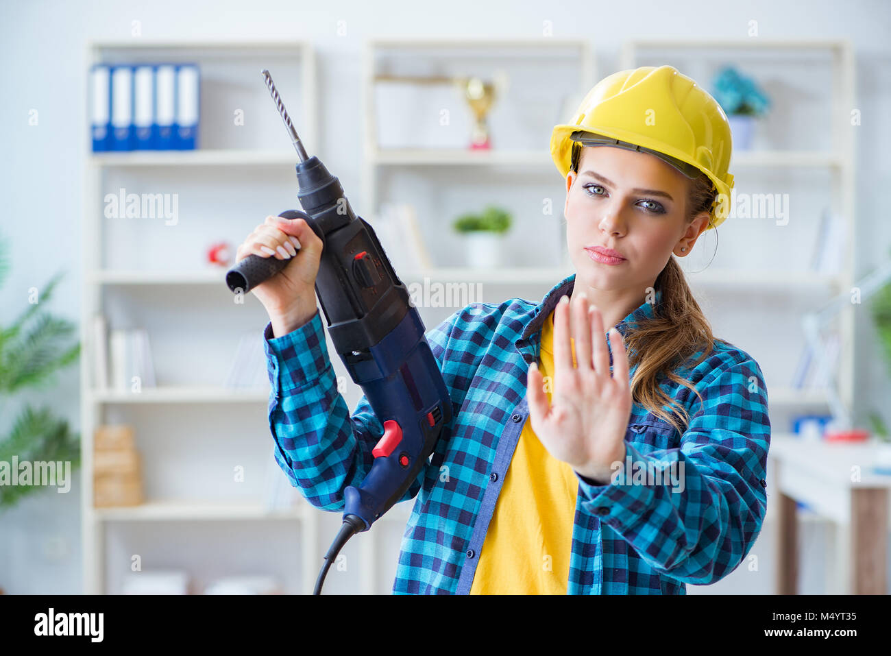 Woman in workshop with drilling drill Stock Photo - Alamy