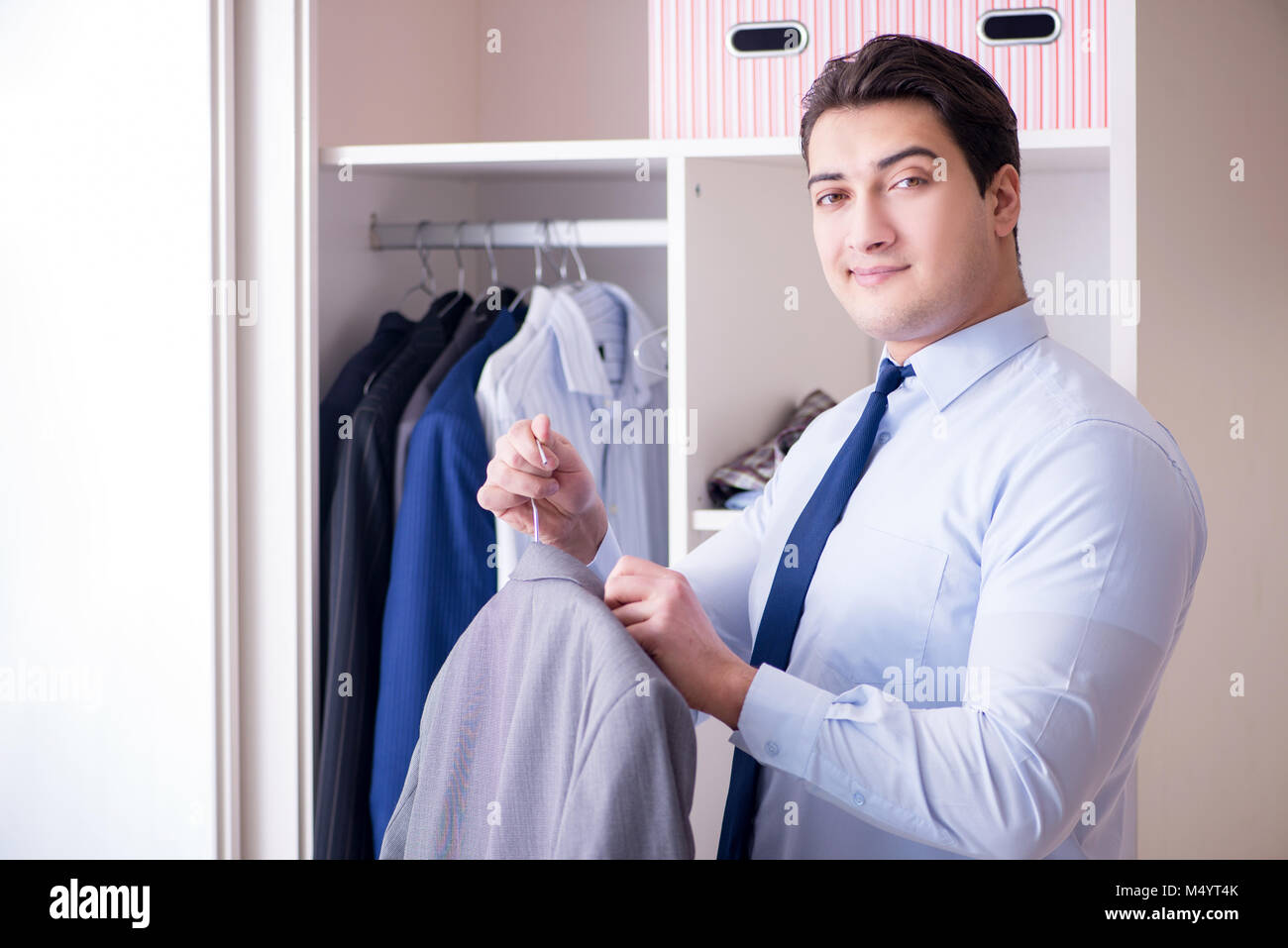 Young man businessman getting dressed for work Stock Photo - Alamy