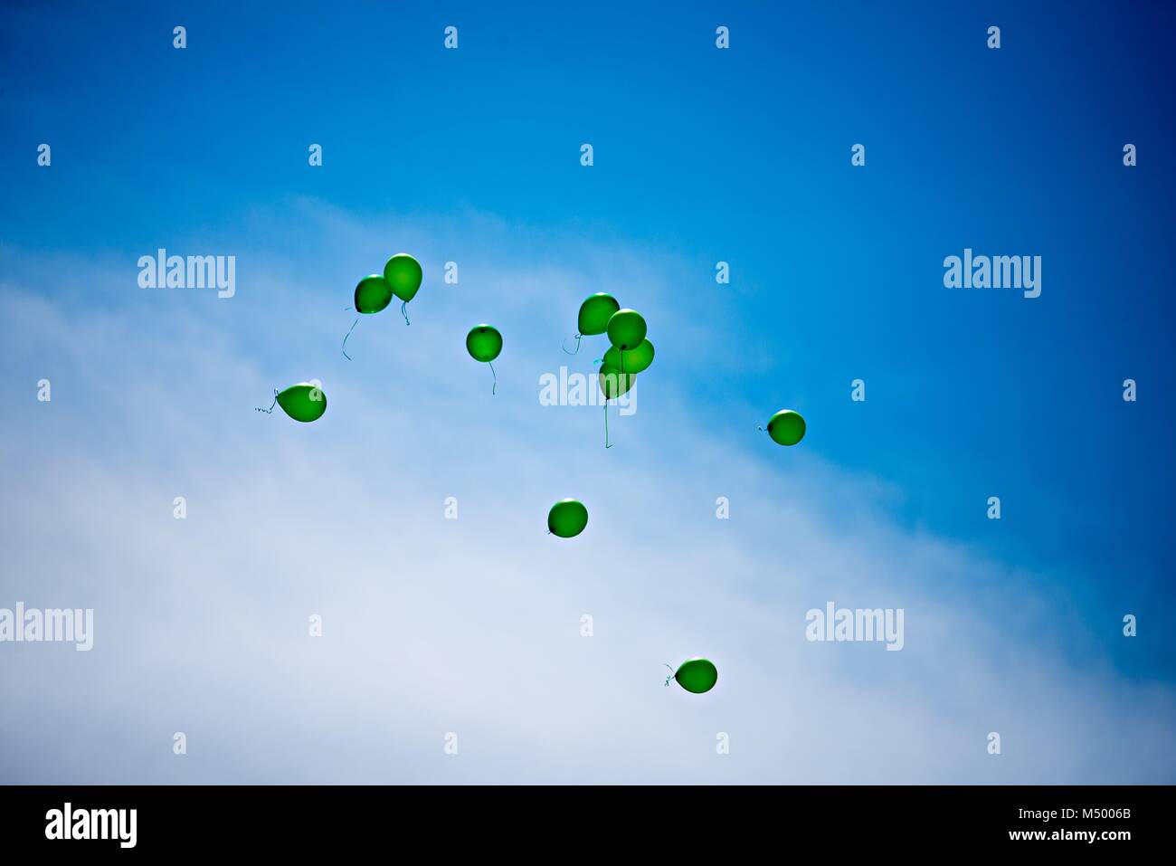 green balloons filled with helium flying towards blue sky Stock Photo ...