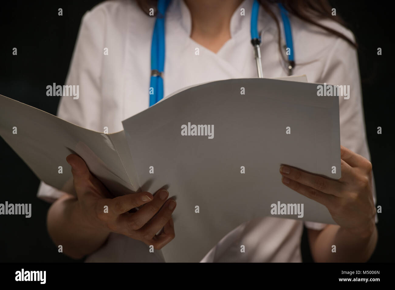 Unrecognizable female doctor reading medical record Stock Photo - Alamy