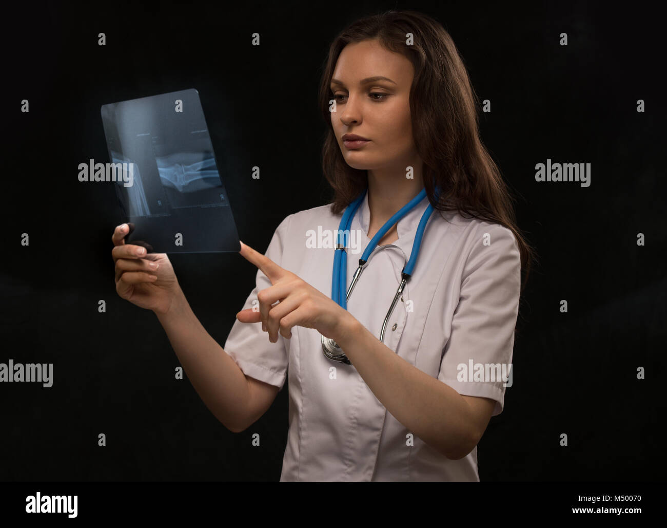 Doctor examining an arm bones radiography Stock Photo - Alamy
