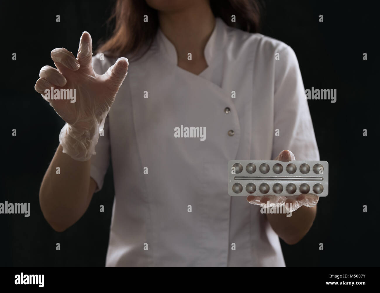 Doctor wearing gloves working with virtual screen and holding tablets ...