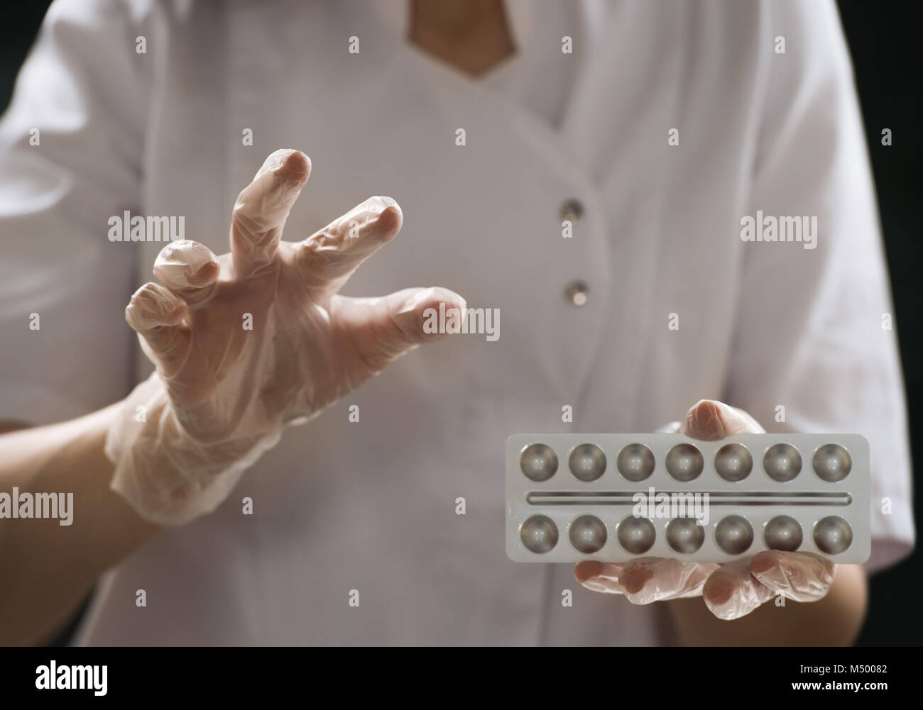 Doctor wearing gloves working with virtual screen and holding tablets ...